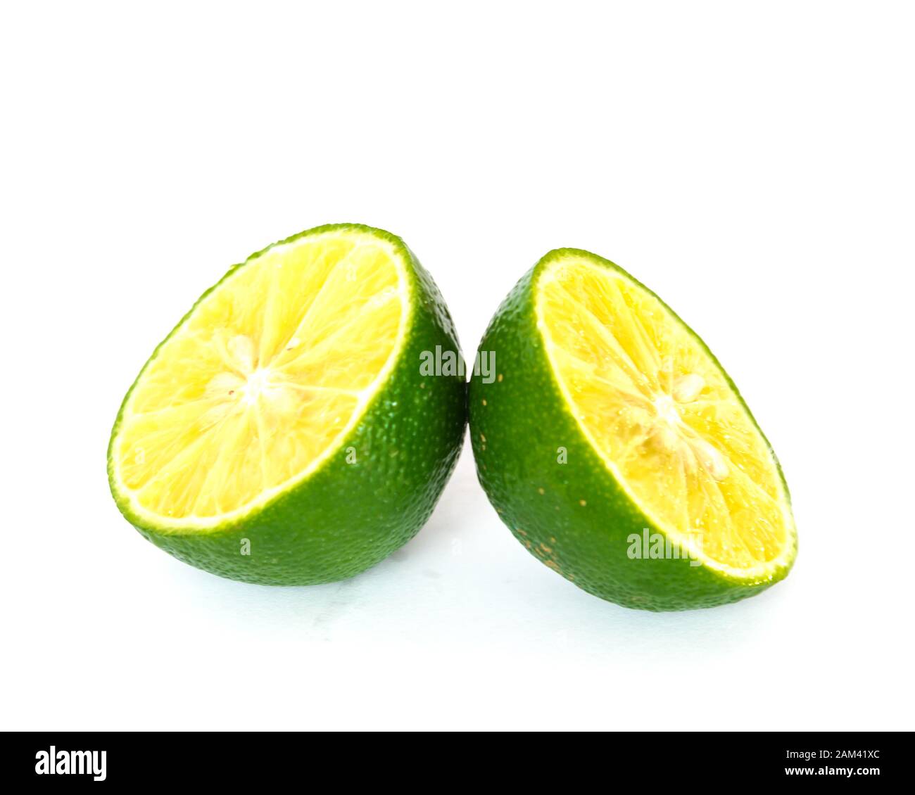 Two half cut limes isolated on white Stock Photo - Alamy