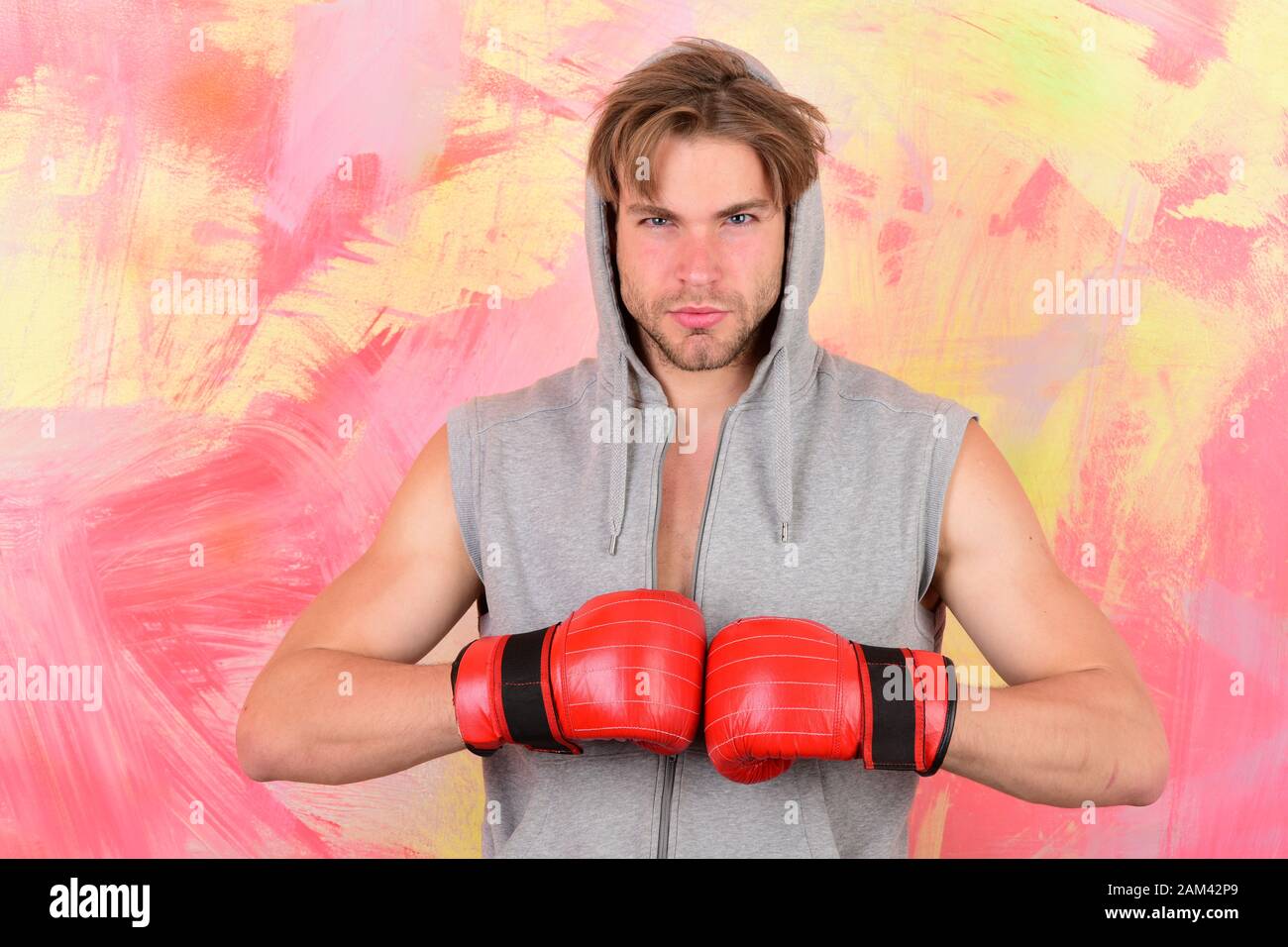 Sports, box and strength concept. Guy in grey sleeveless hoodie wears ...