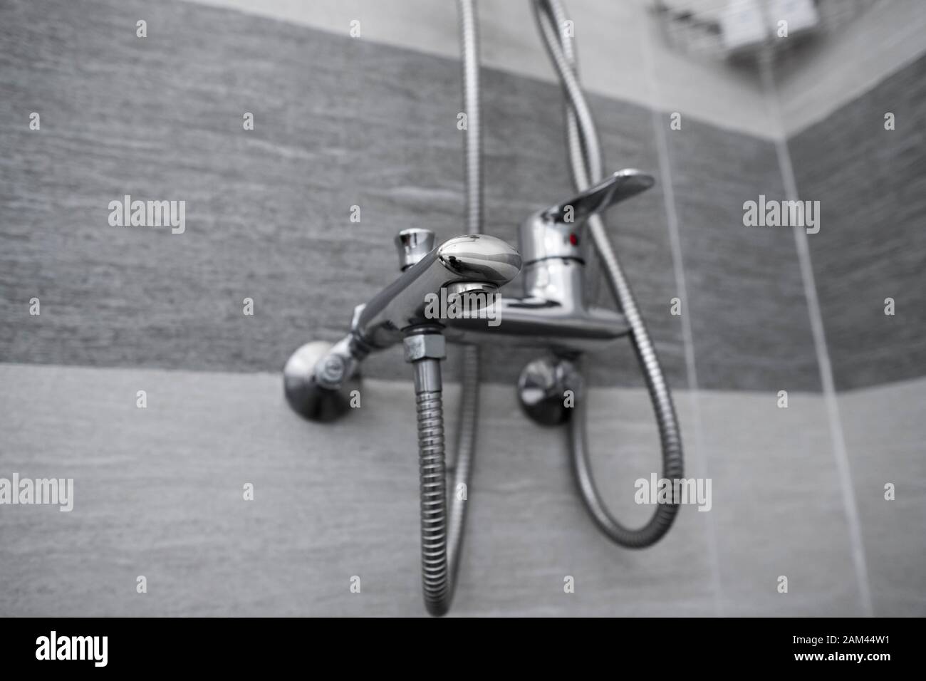 Modern designer tap and shower in bathroom. Closeup of chrome shower ...