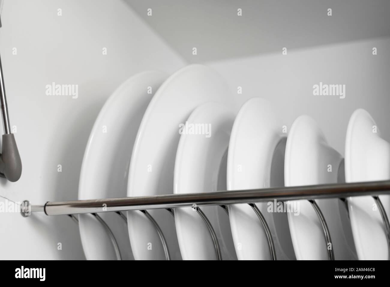 Dish drying metal rack with big nice white clean plates. Traditional ...