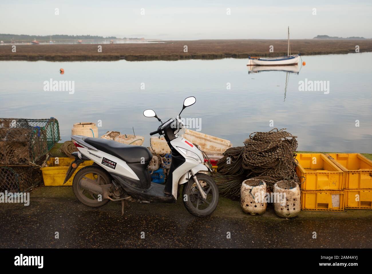 Motorbike on a quay by sea with fishing gear around Stock Photo - Alamy