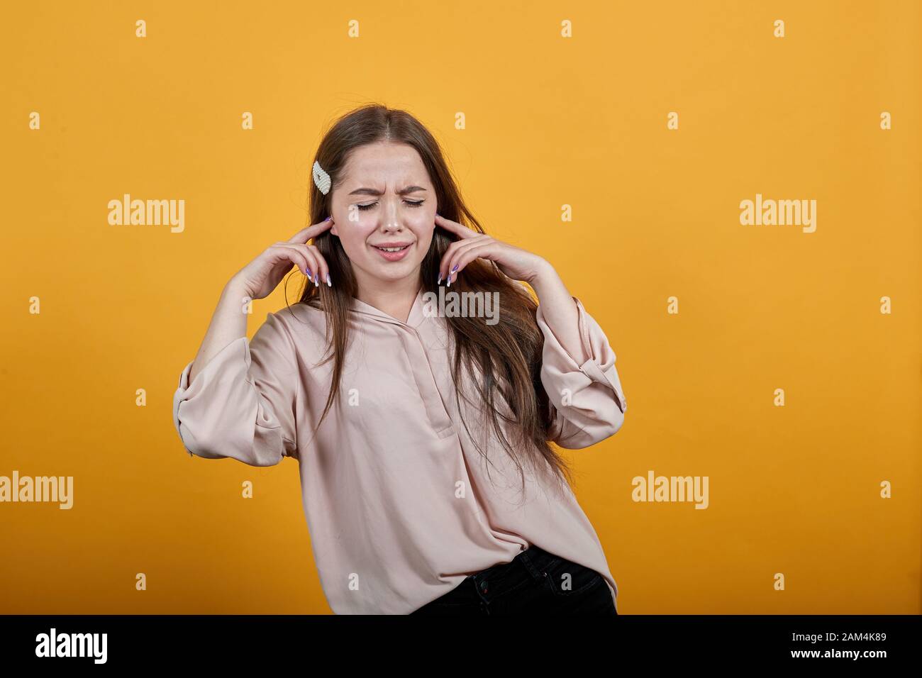 Young disappointed woman closed ears with fingers, squeezing face Stock ...