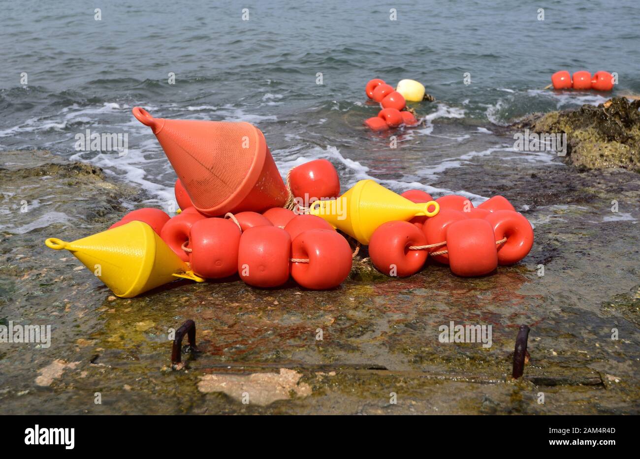Group of colourful marker buoys washed up on the shore Stock Photo - Alamy