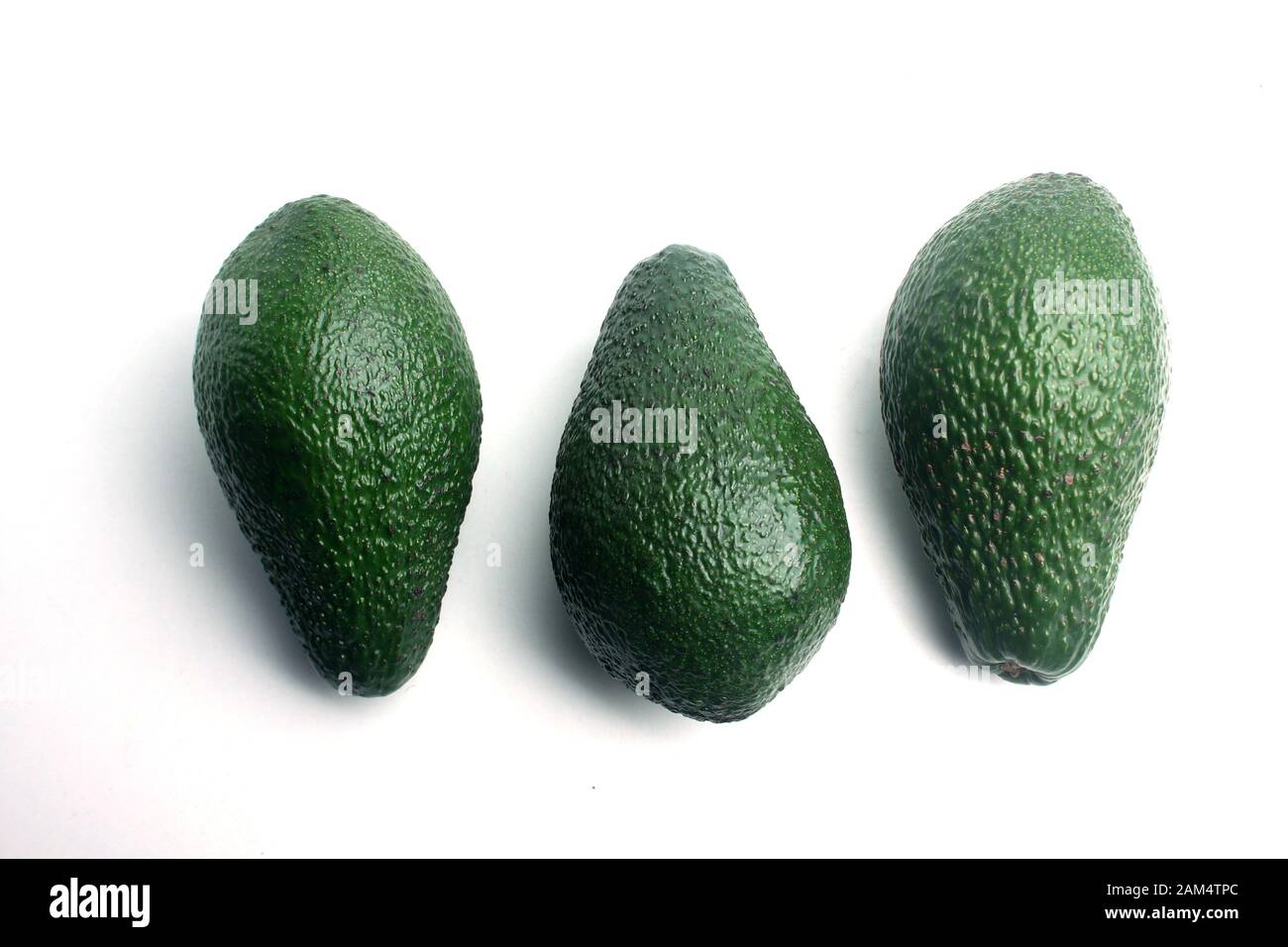 three avocado isolated on white background flat lay. Image contains ...