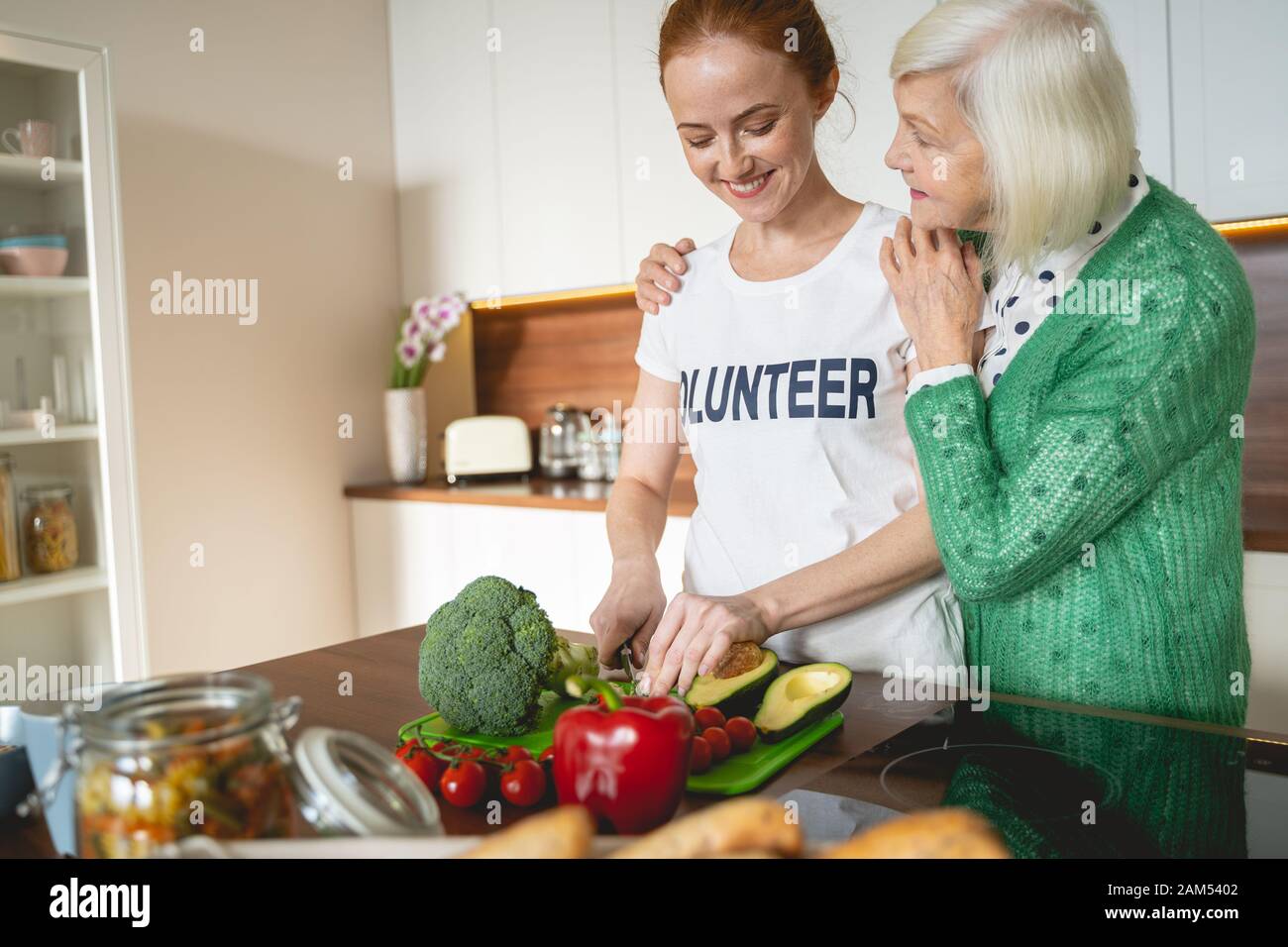 Beautiful young social worker cooking healthy dinner Stock Photo - Alamy