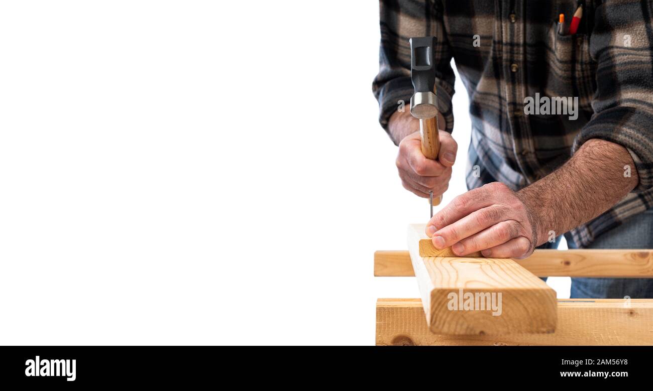 Close-up. Carpenter with hammer and nails fixes a wooden board ...