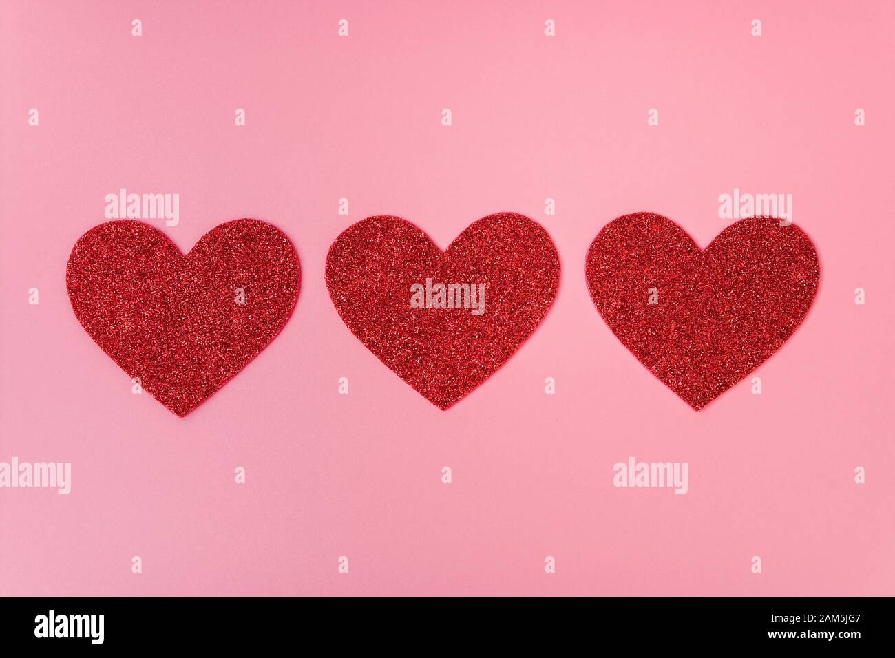 Three red heart shape figures on background Stock Photo - Alamy
