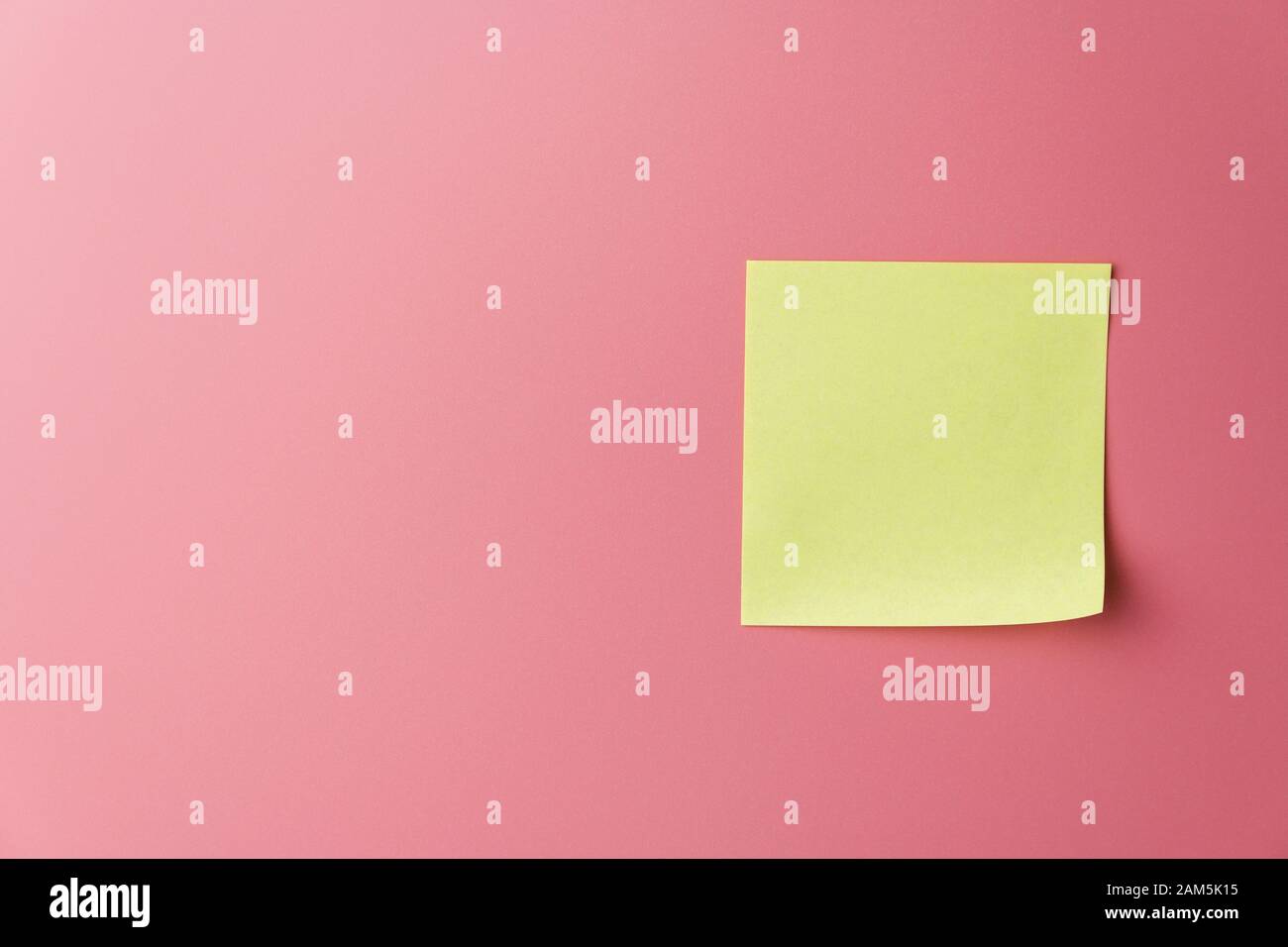 one yellow sticky note reminder on a red background Stock Photo - Alamy
