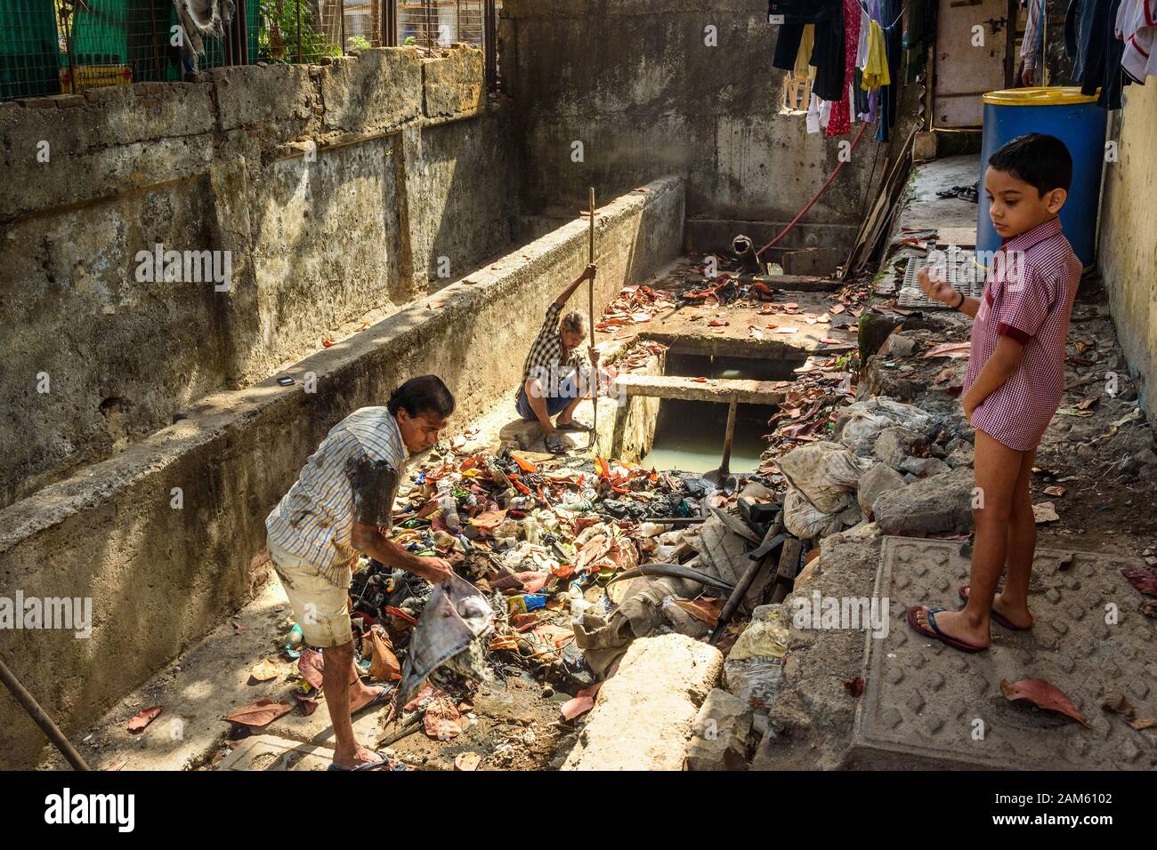 Indian man cleaning gutter in Dharavi Slum at Mumbai. India Stock Photo ...