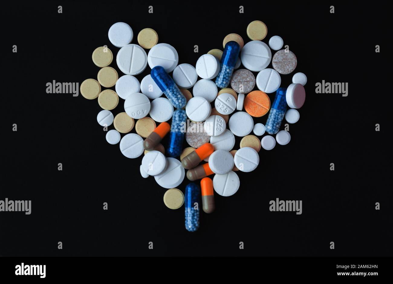 Heap of colorful pills in the shape of a heart, tablets and capsules ...