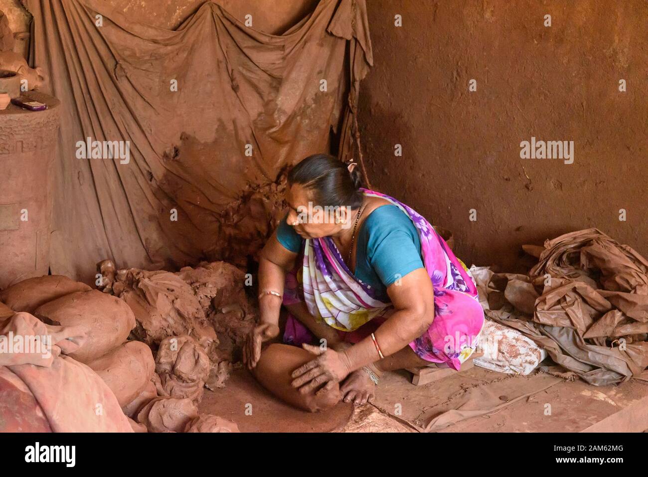 Indian woman prepares clay for making pots in Dharavi Slum at Mumbai ...