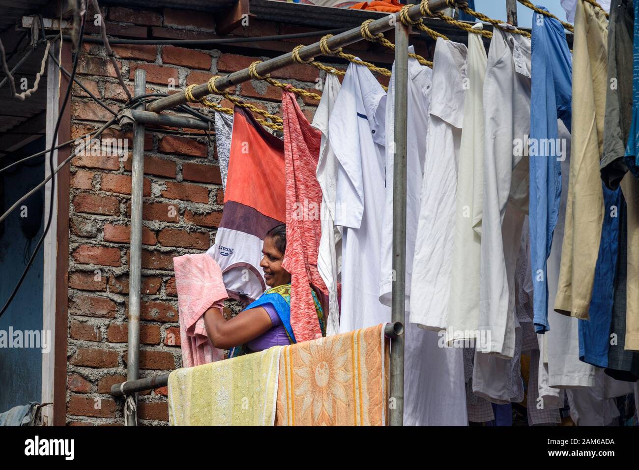 Indian woman washing clothes outside hi-res stock photography and ...