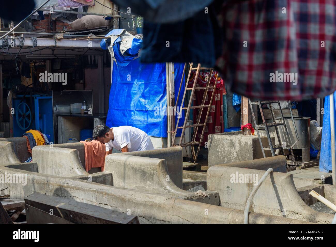 Indian woker washing clothes in Dhobi Ghat is outdoor laundry in Mumbai ...