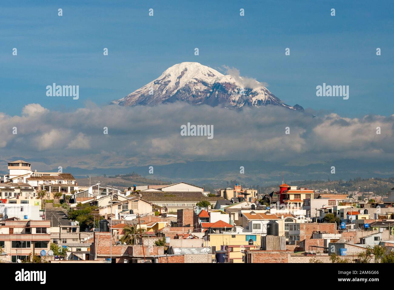 Mount Chimborazo volcano (6268m) seen across the rooftops of the town ...