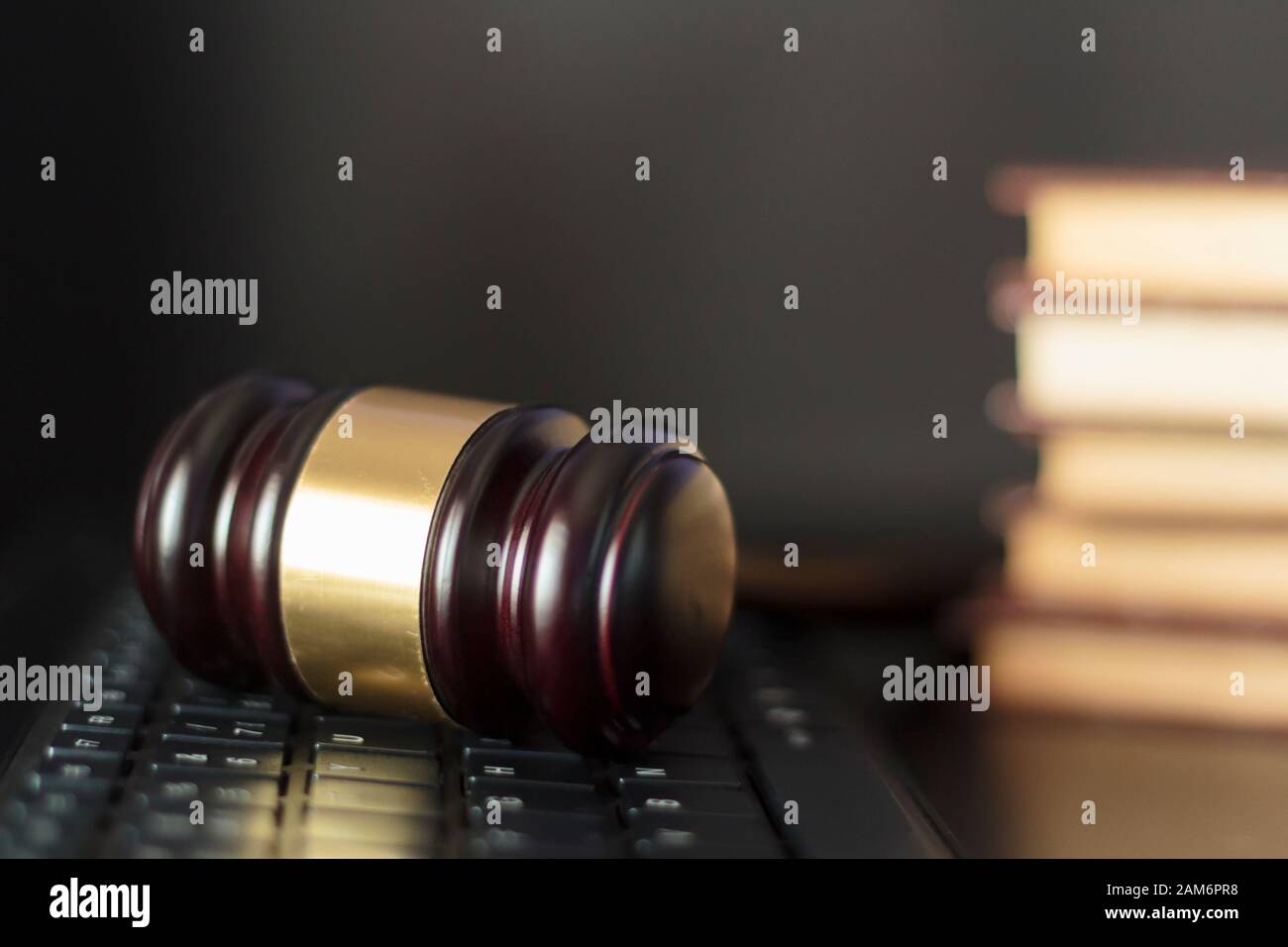 Judge's gavel on computer keyboard with copy space with law books on ...