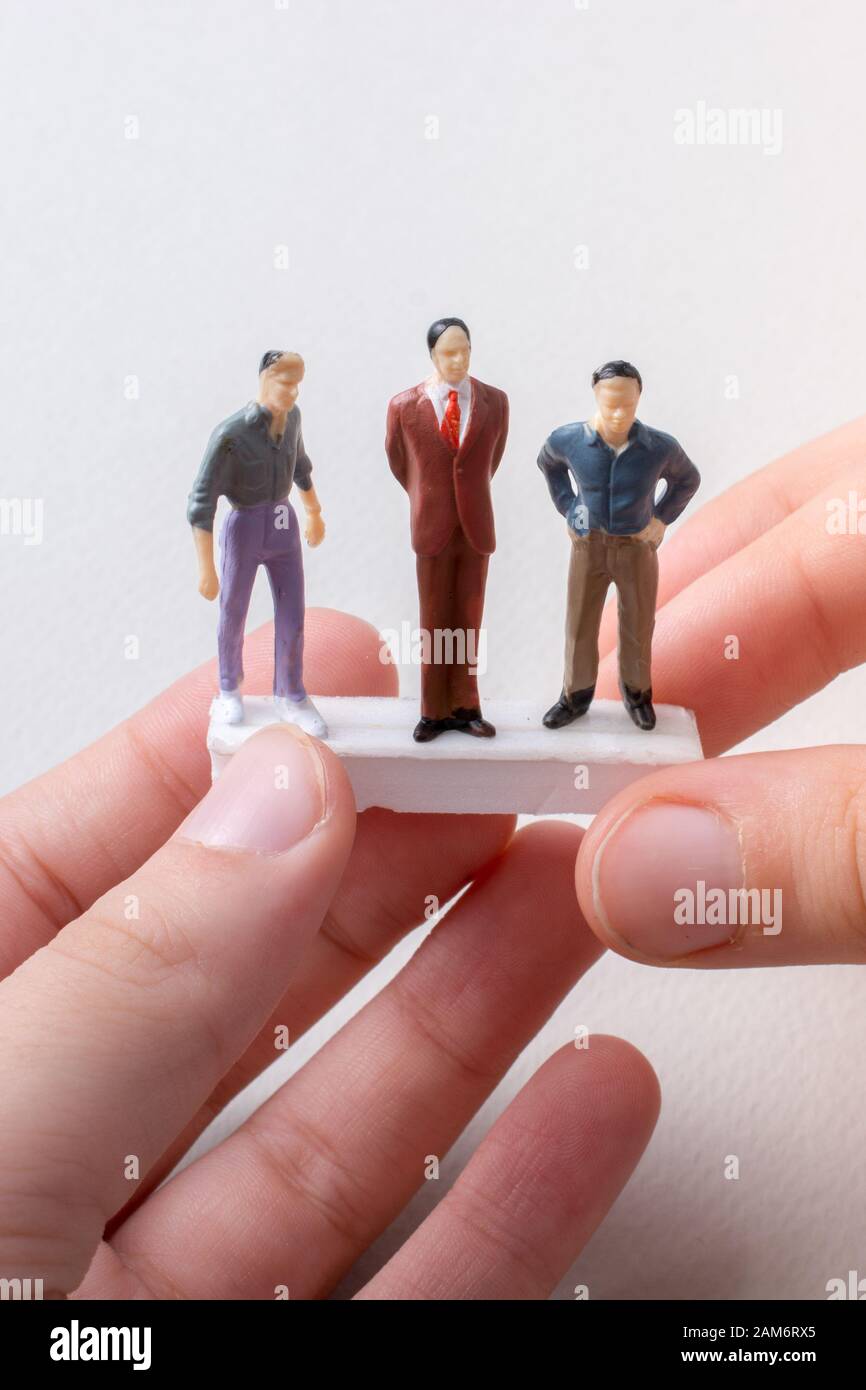 Tiny figurines of men miniature model in hand Stock Photo - Alamy