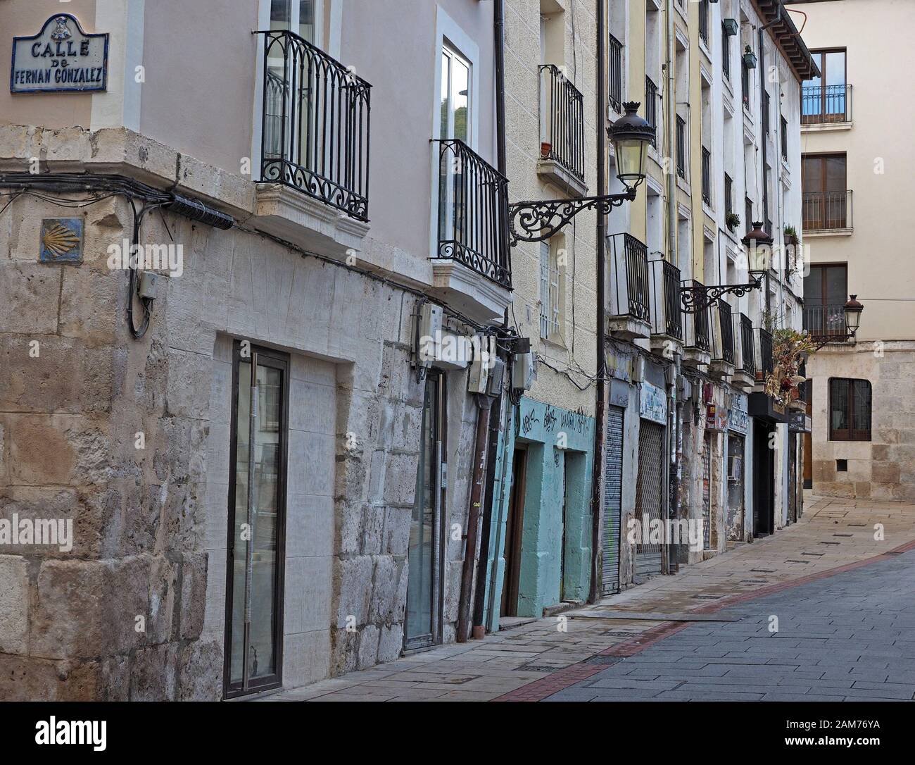 historic bulging white stone buildings with sign of Camino de Santiago ...