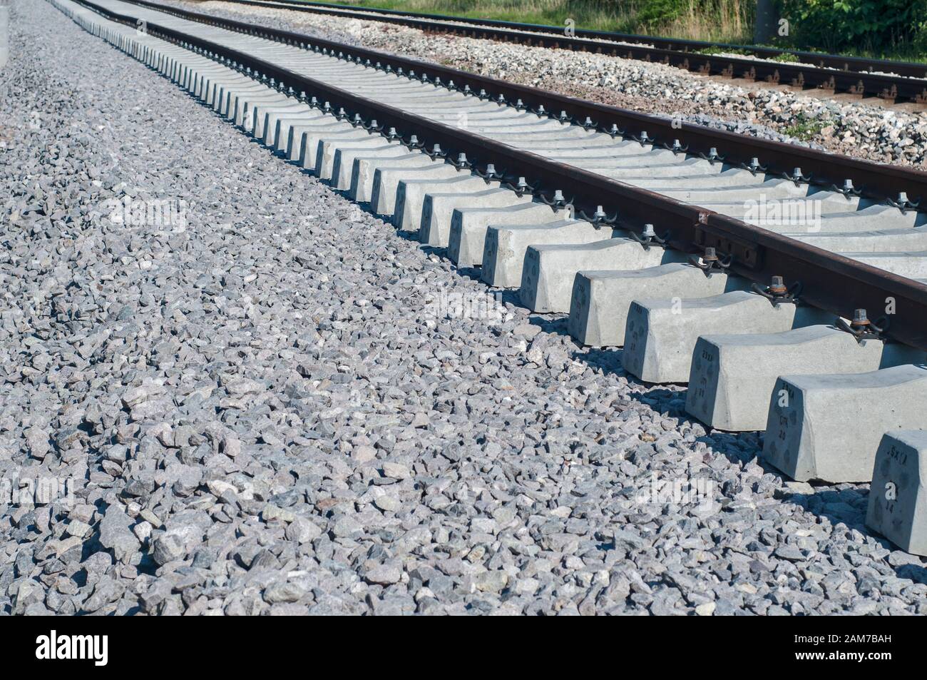 New railway rails with concrete sleepers closeup Stock Photo - Alamy