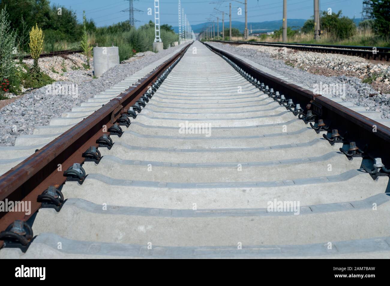 New railway rails with concrete sleepers closeup Stock Photo - Alamy