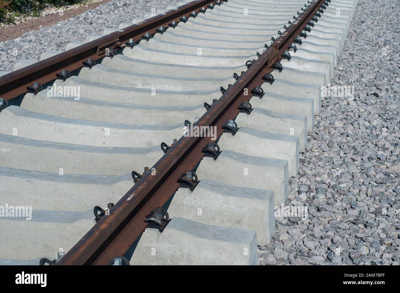 New railway rails with concrete sleepers closeup Stock Photo - Alamy