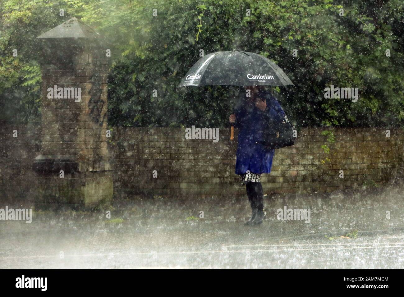 A woman is caught in a heavy rain shower in Belfast City Center ...