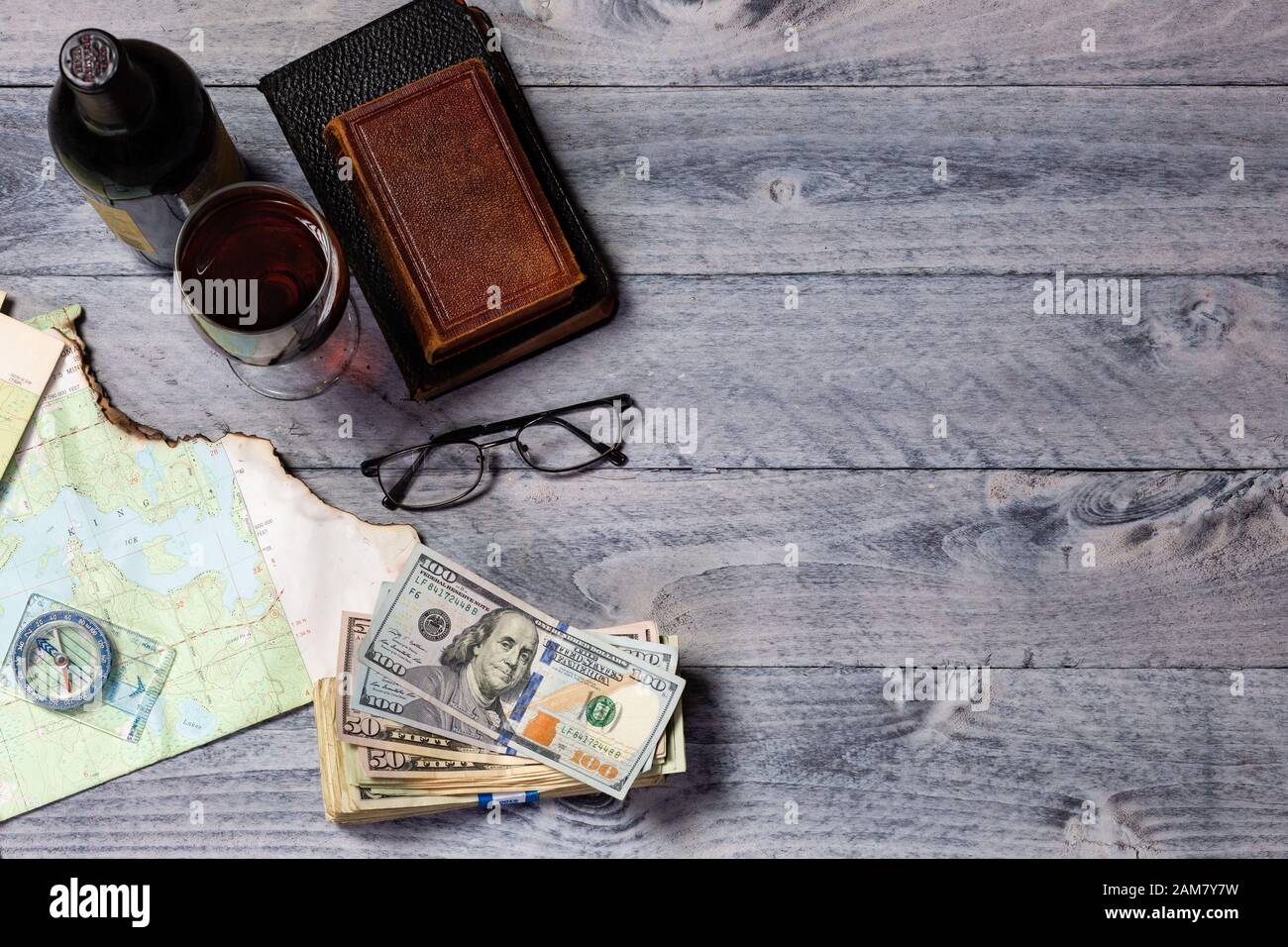 Map, compass, wine, money, books and glasses ready for a journey ...