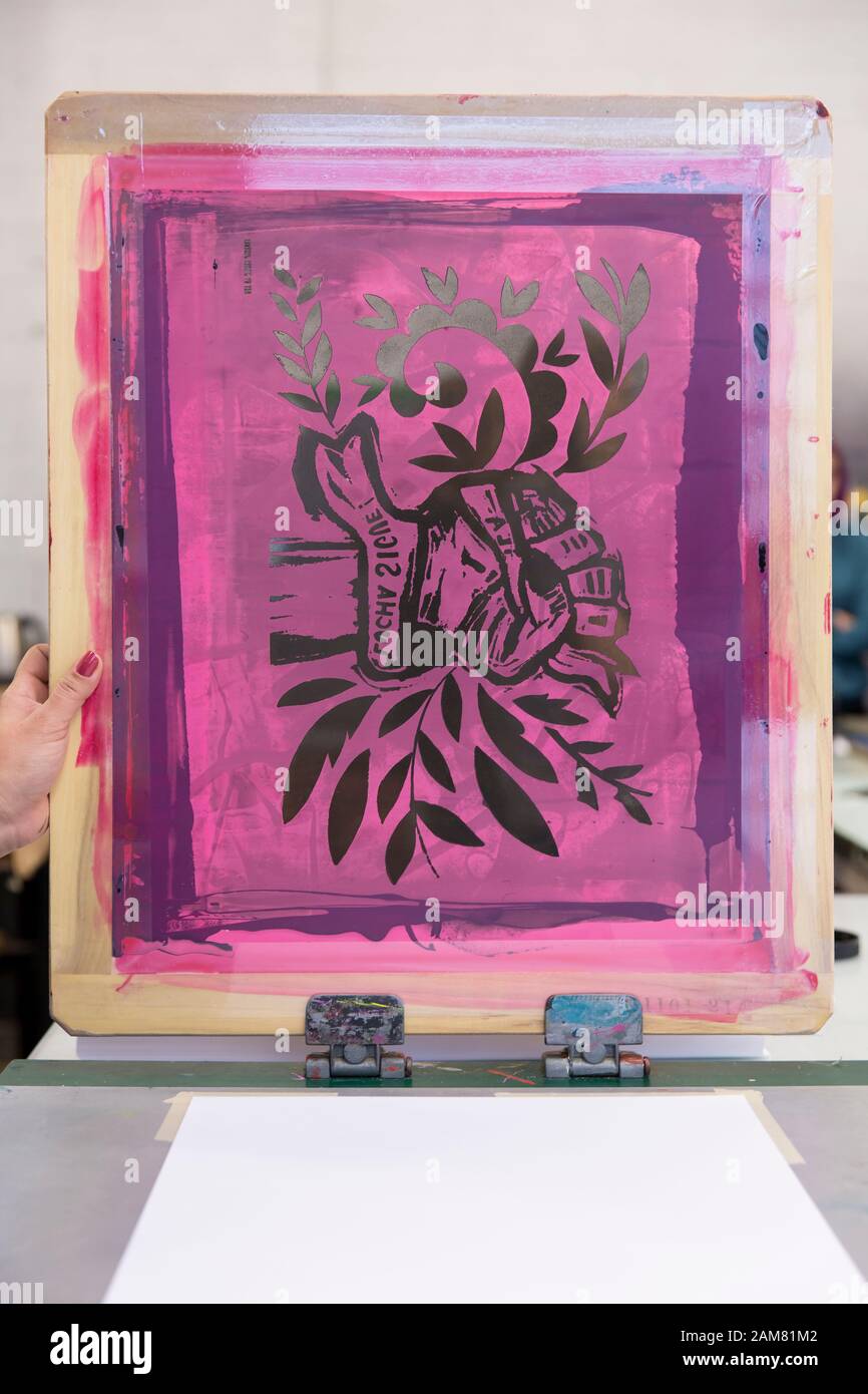 Artist Brittany Houk prepares a screen print by Eileen Jimenez at the ...