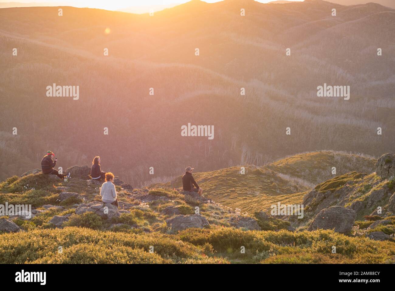 Visitors sitting on rocks in Australia Alpine National Park enjoying ...