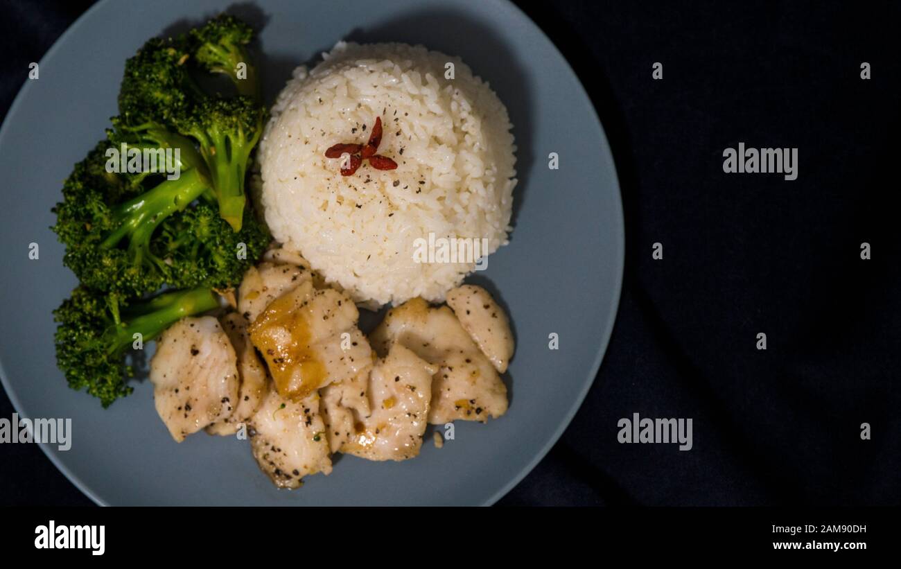 Delicious fried broccoli and fish with rice for one person, against the ...