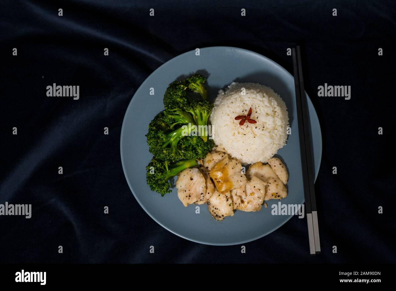 Delicious fried broccoli and fish with rice for one person, against the ...