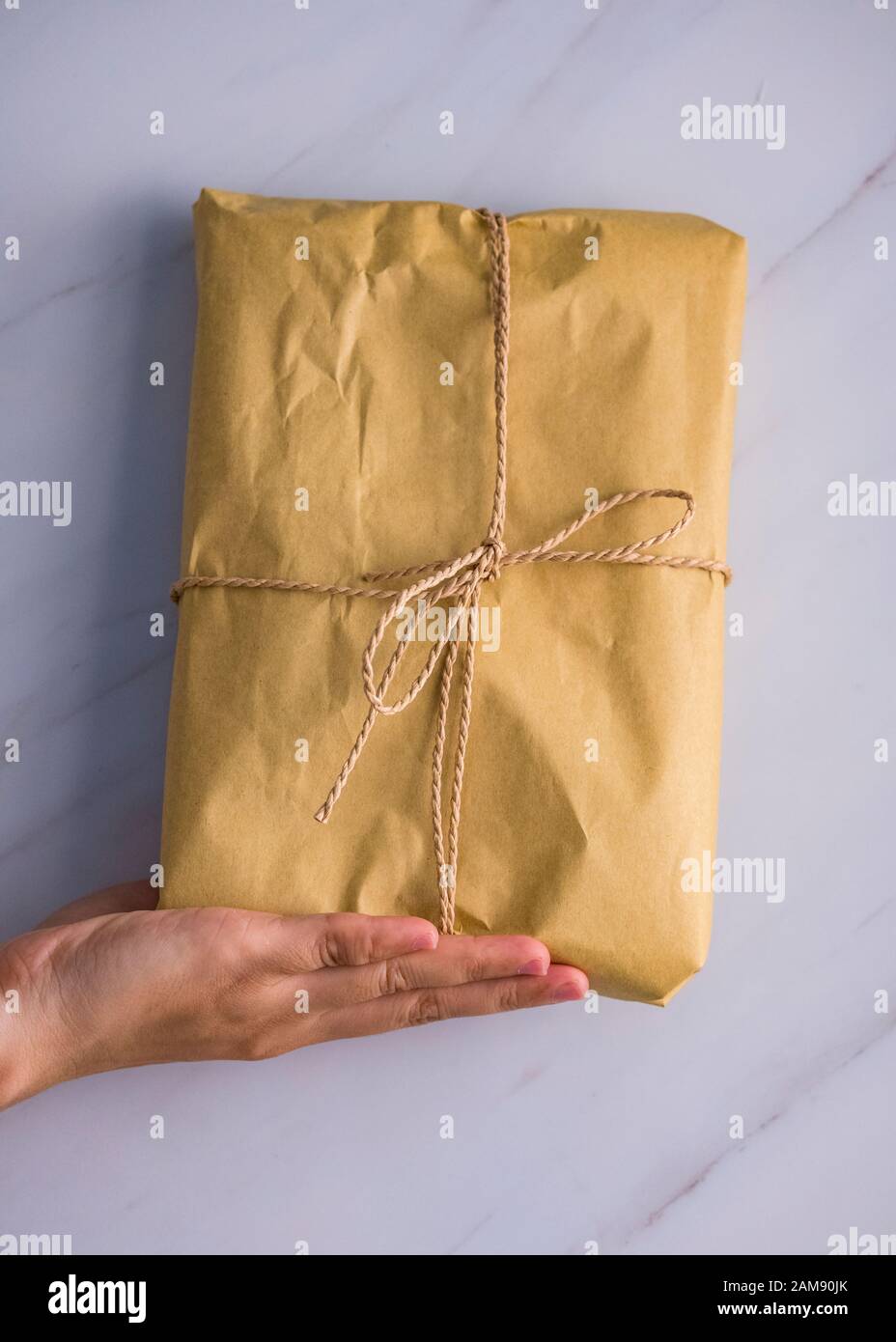 Young woman's hand is holding a post mail on white marble wall ...