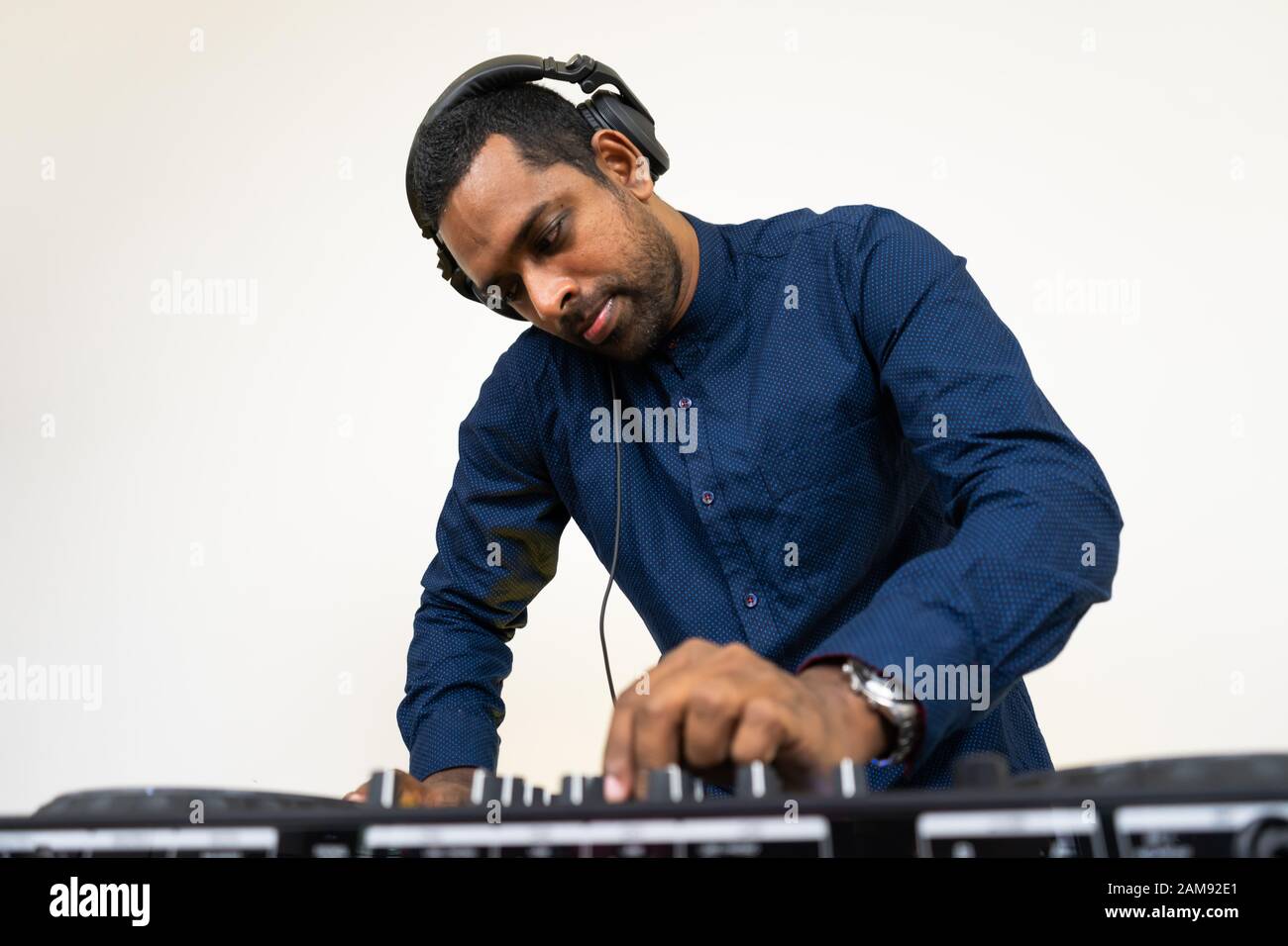 Male DJ playing music on white background Stock Photo - Alamy