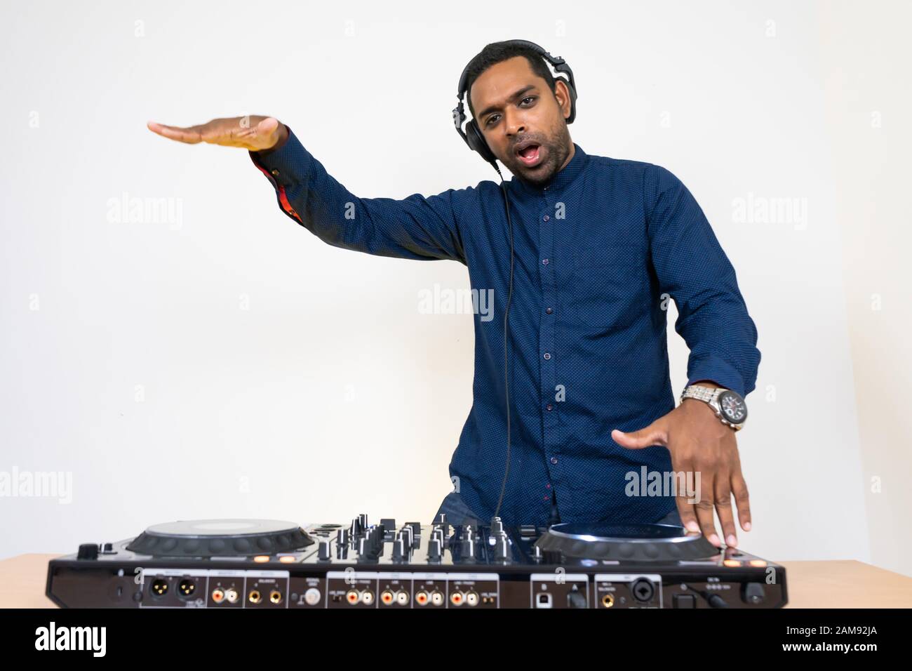Male DJ playing music on white background Stock Photo - Alamy