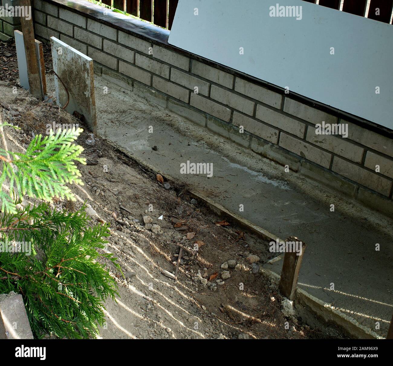 recently poured, concrete foundation under the garden fence Stock Photo ...