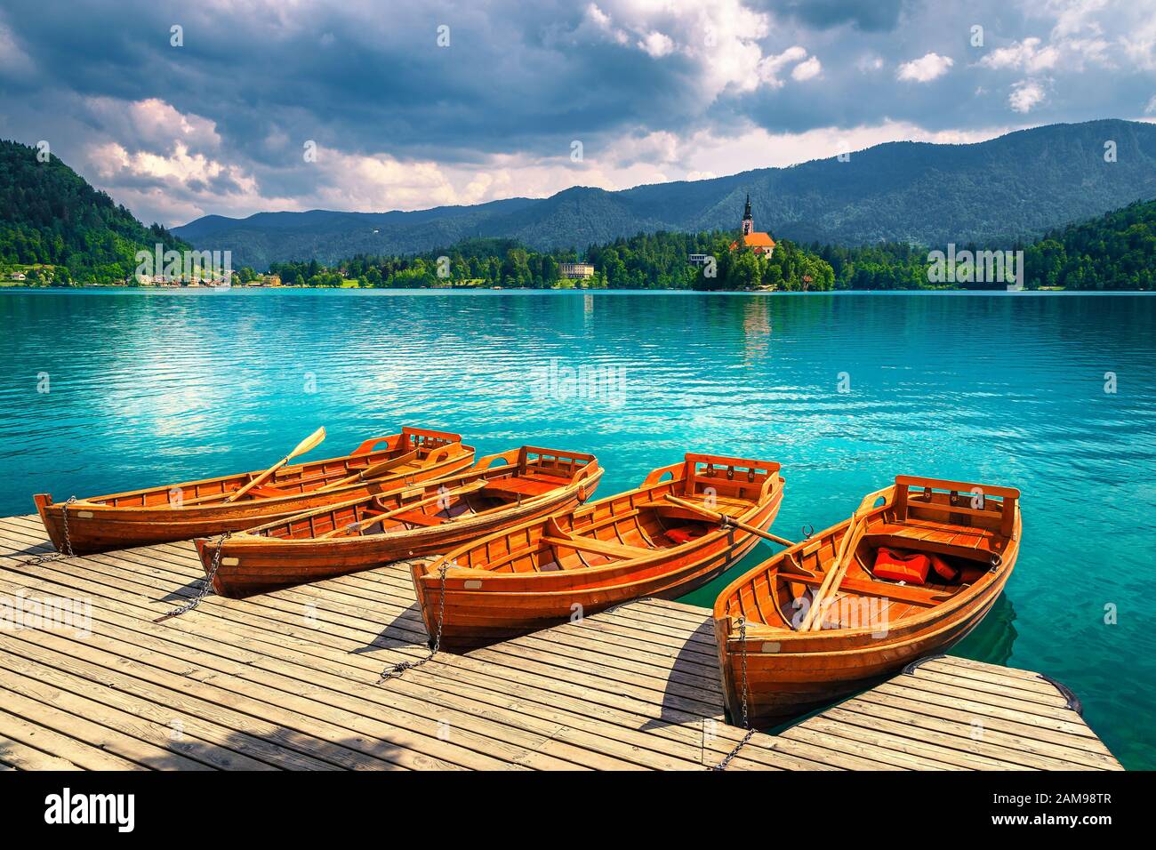 Old wooden rowing boats moored at the pier on the lake Bled. Gorgeous ...