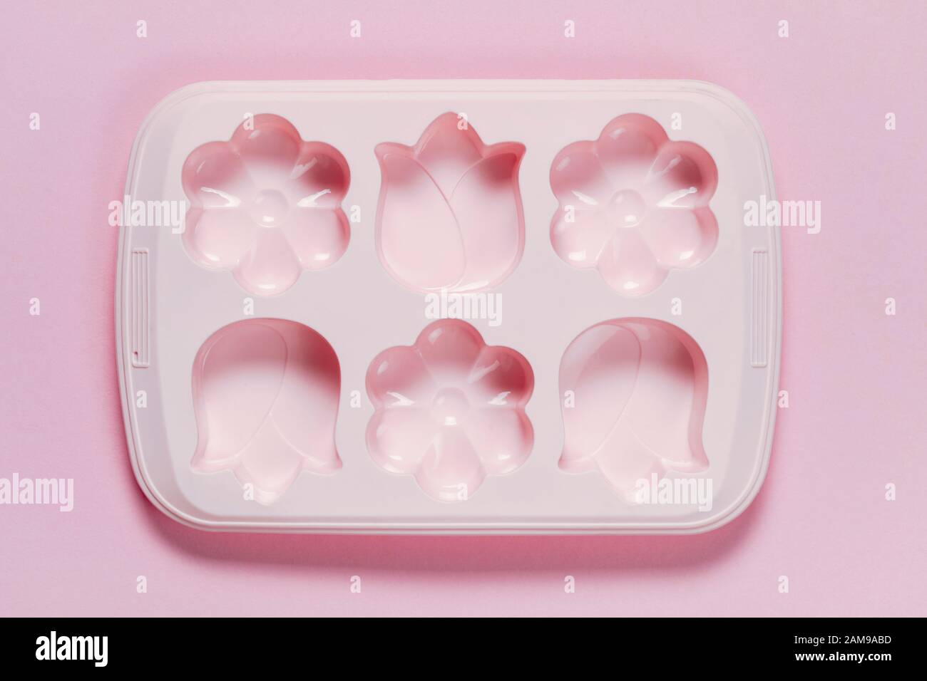 Pink silicone mold on pink background, top view Stock Photo - Alamy