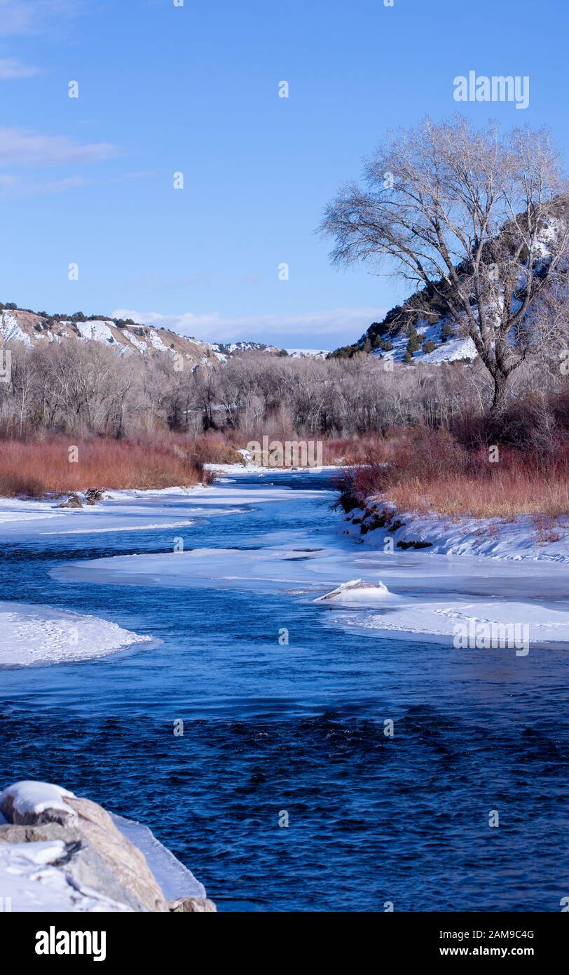 winter scene on an icy river with dried grasses and snowy banks Stock ...