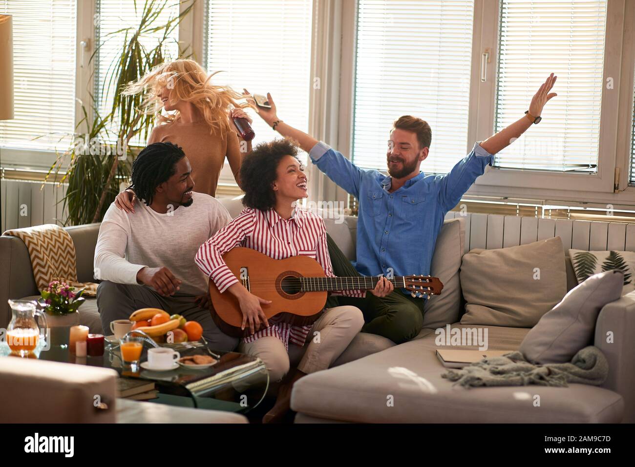 Young happy people enjoying in sound of guitar Stock Photo - Alamy