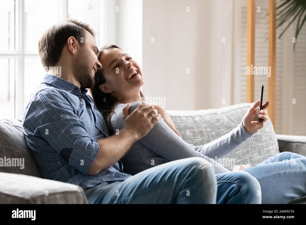 Happy millennial couple smile making selfies on cellphone Stock Photo ...