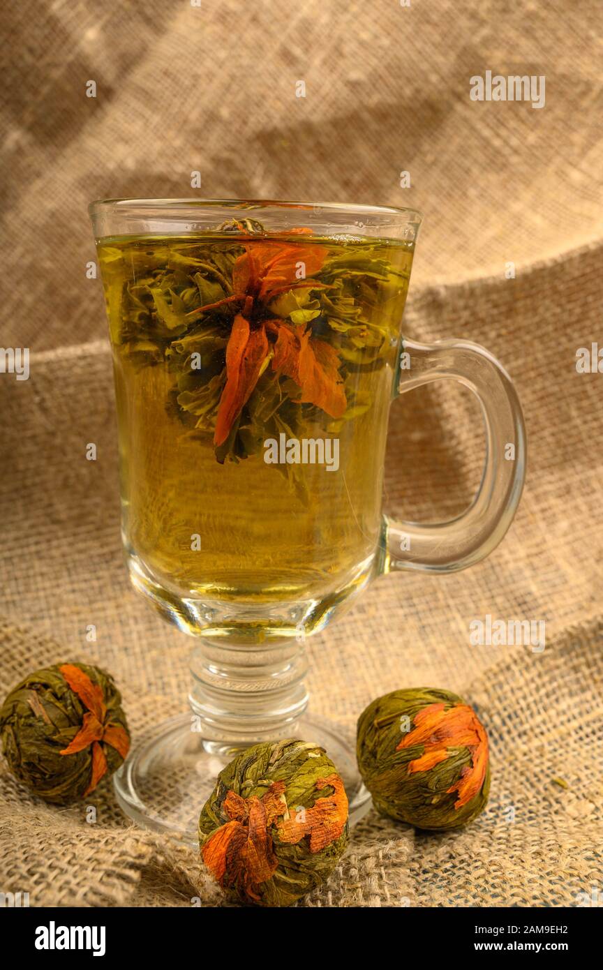 Flower tea brewed in a glass Cup and balls of flower tea on a ...
