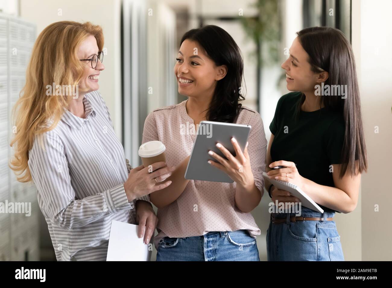 Colleagues during break meet in office hall enjoy informal talk Stock ...