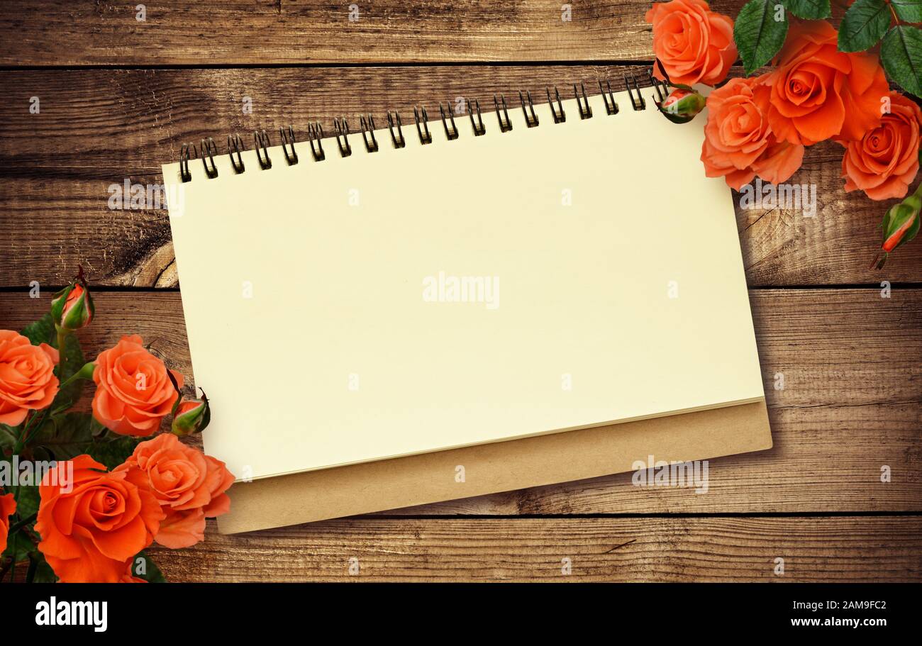 Notepad and roses on wooden background Stock Photo - Alamy