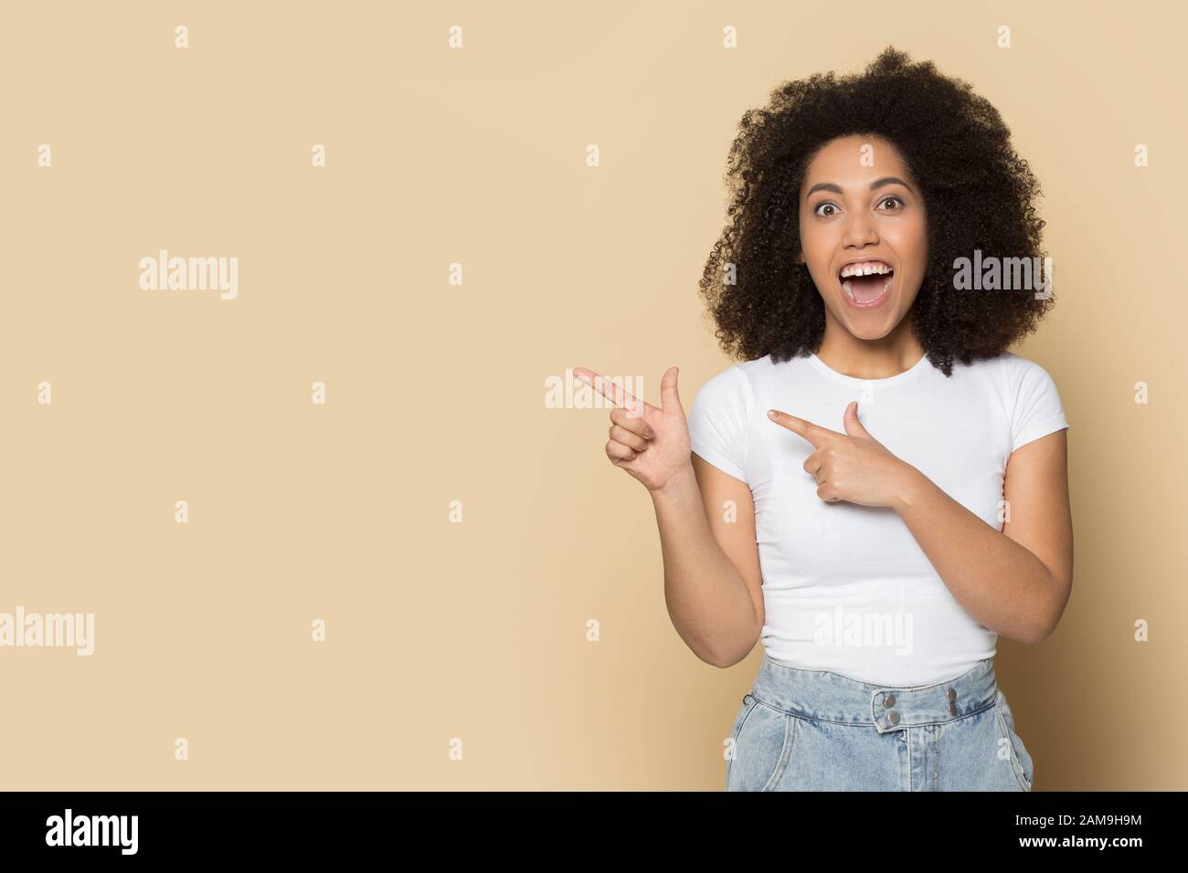 Surprised young african american girl pointing fingers on copy space ... Surprised young african american girl pointing fingers on copy space ...