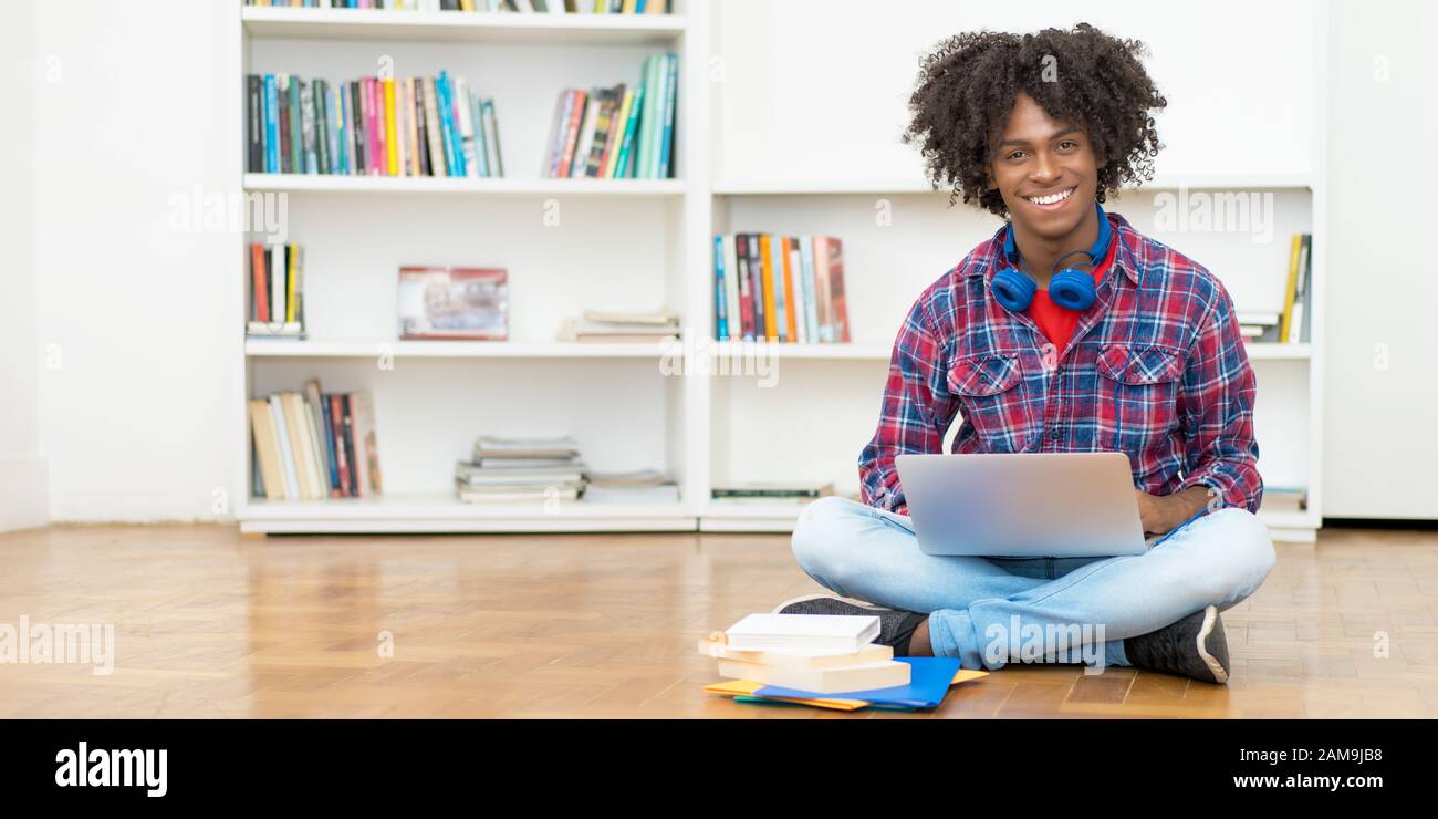 African american male student with computer and copy space indoor at ...