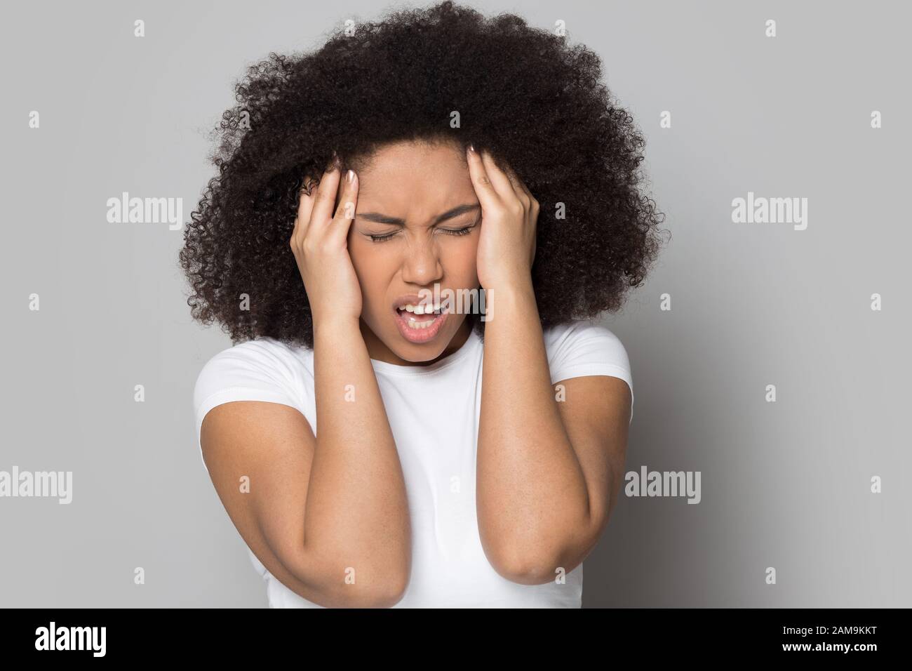 Unhappy young african american woman suffering from strong head ache ...