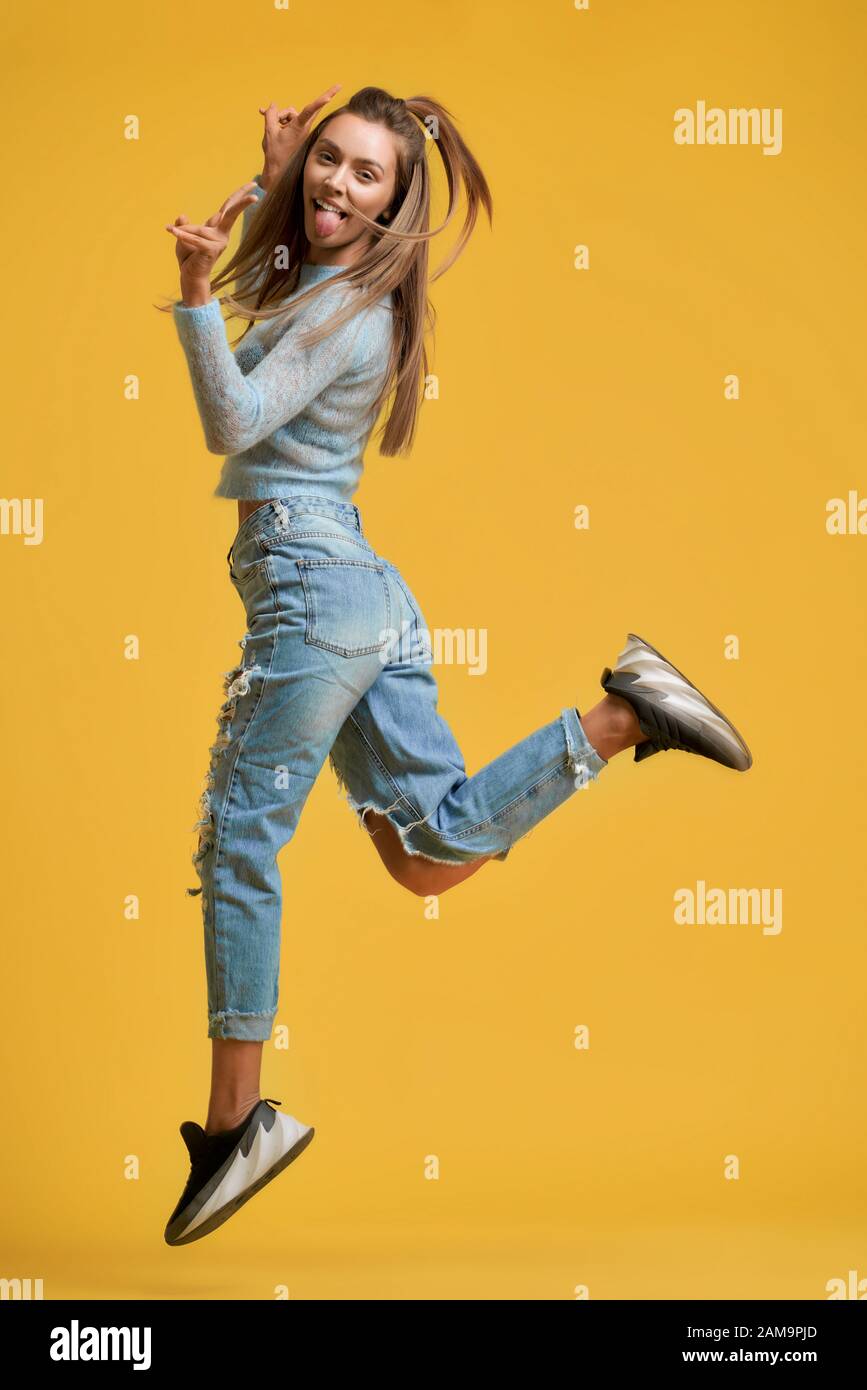 Side view of girl with brown hair in full height raising right leg up ...