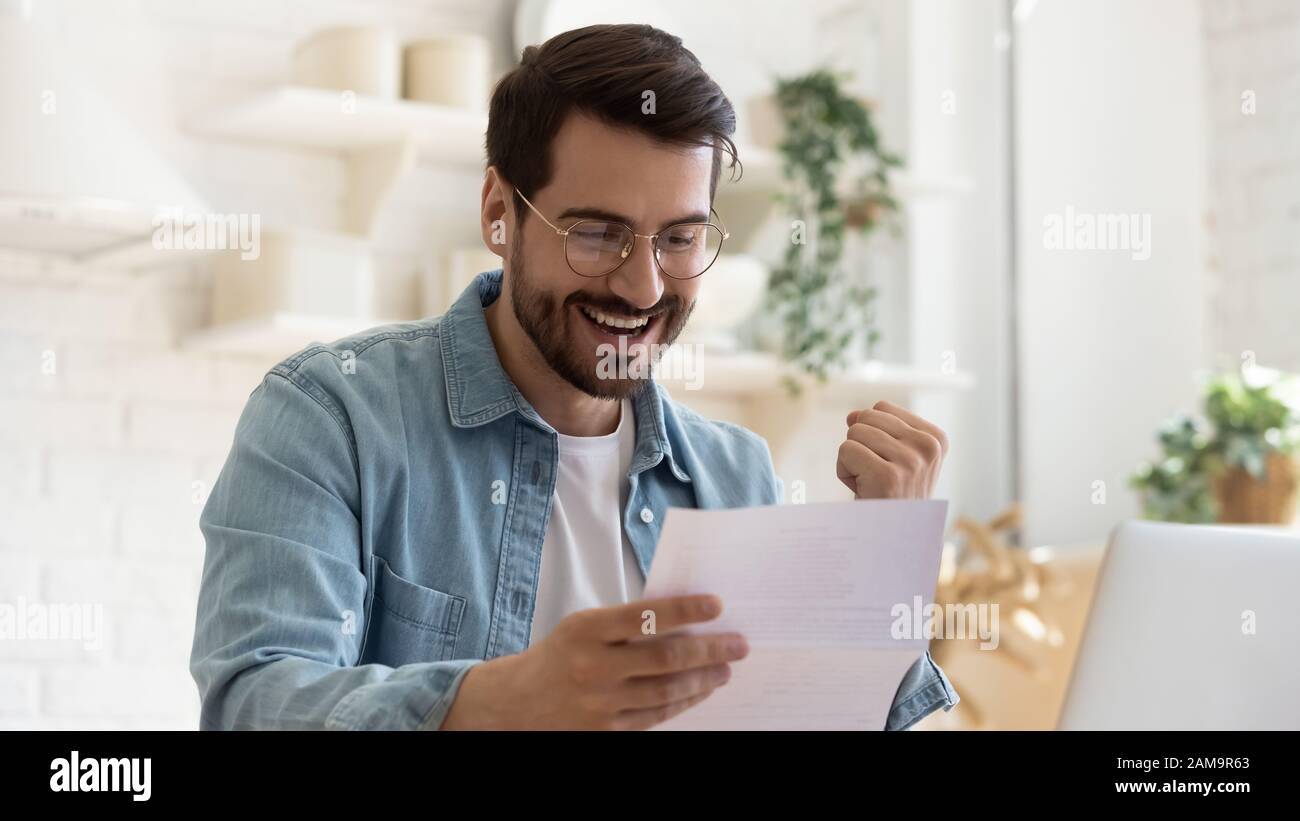Happy young man reading paper letter with good news Stock Photo - Alamy