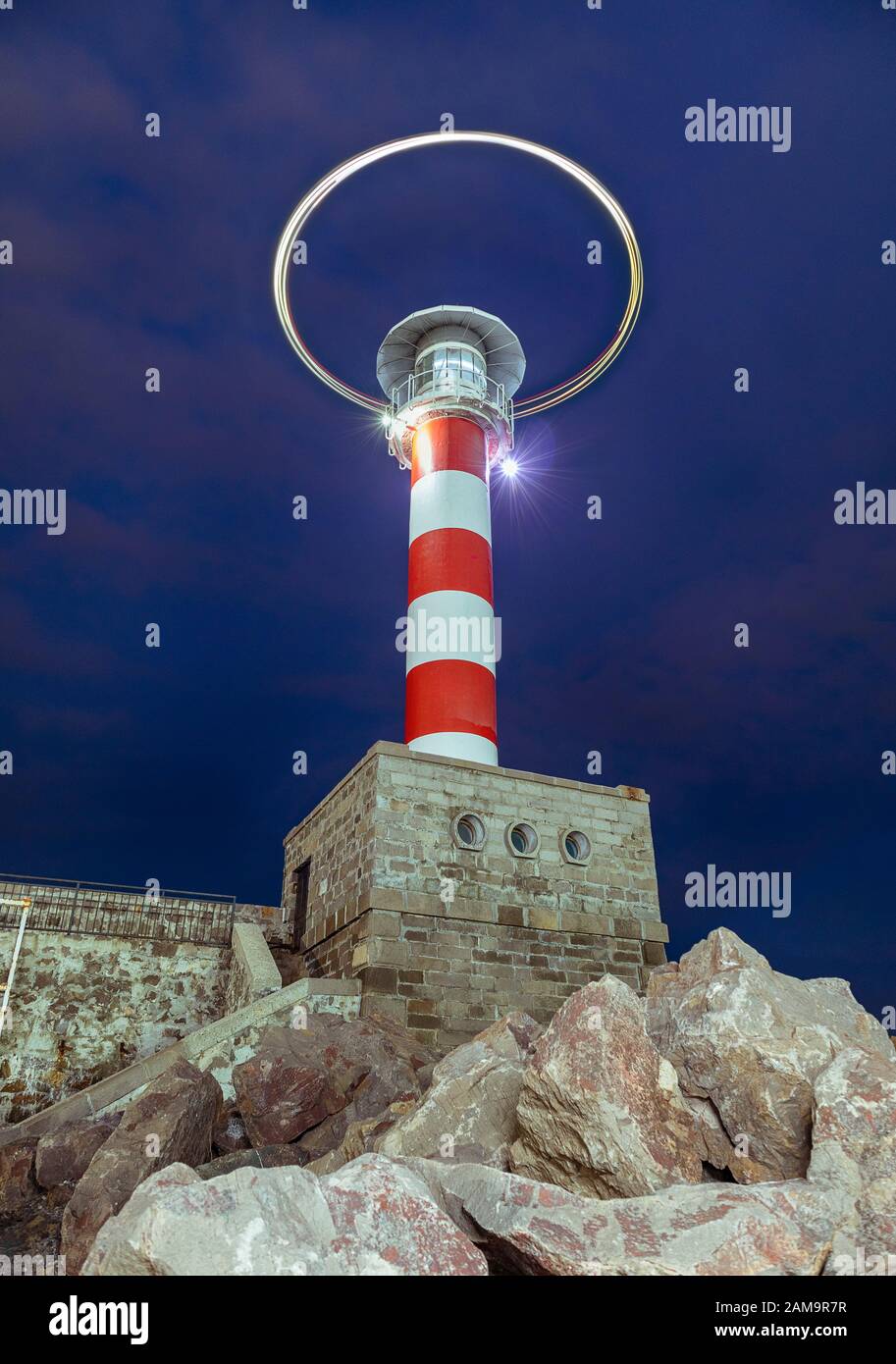 long exposure photography of lights forming shapes behind a lighthouse ...