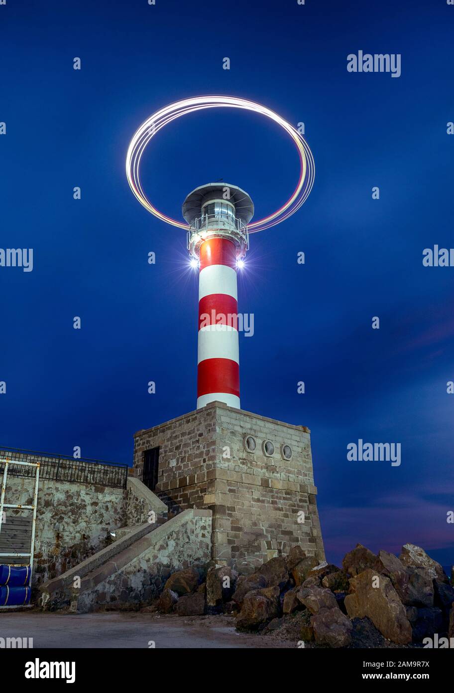long exposure photography of lights forming shapes behind a lighthouse ...