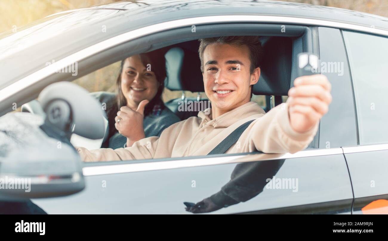 Happy student of driving school showing car keys Stock Photo - Alamy
